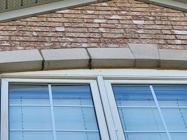 How to fix this ? Brick that's sticking out above window ...